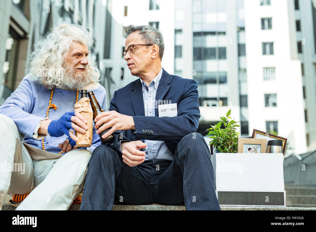 Two men clanging their beer bottles Stock Photo - Alamy