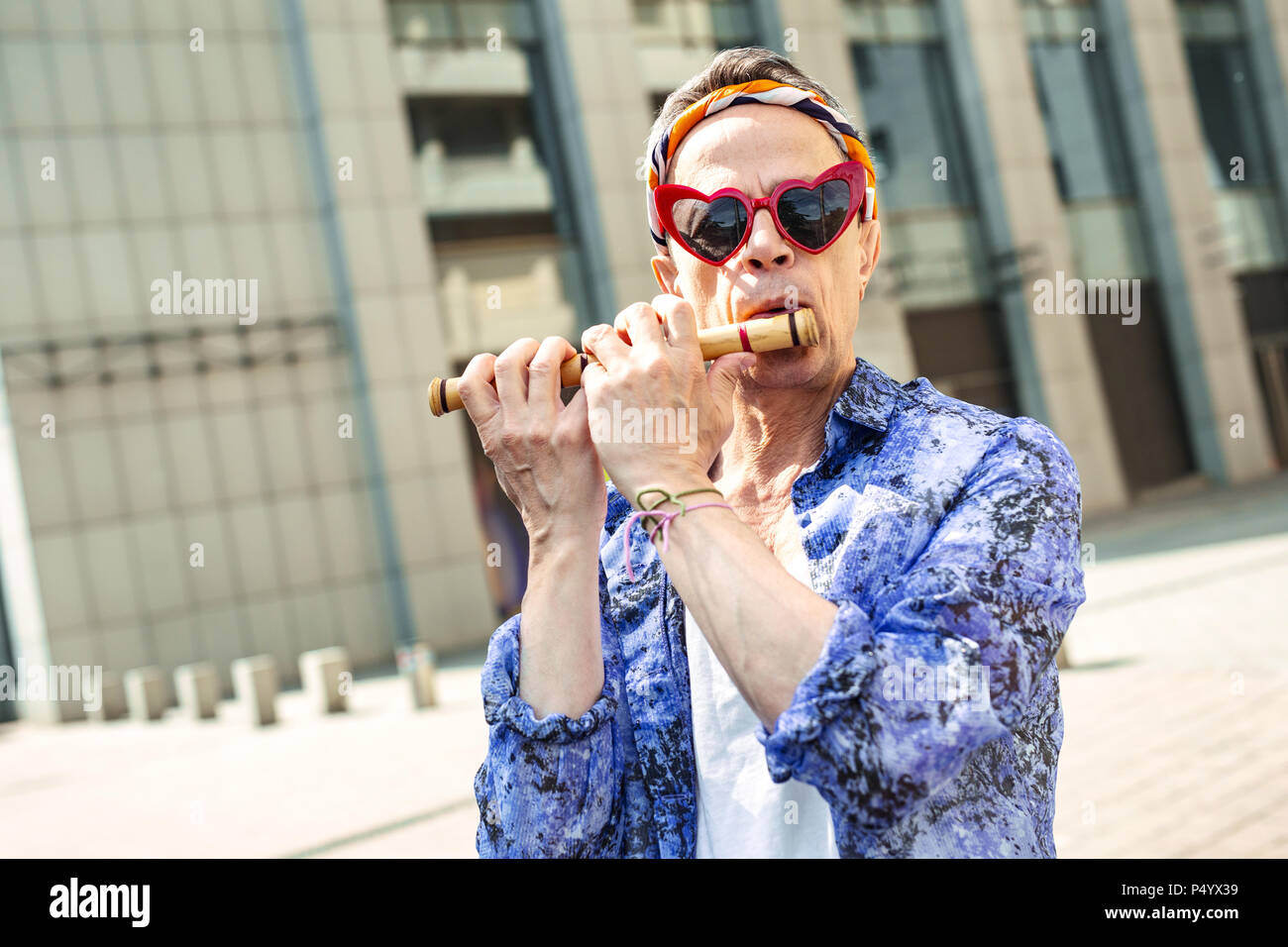 Hippy man wearing shining blue jacket playing the harmonica Stock Photo ...