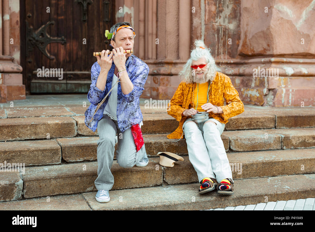 Street musicians playing music sitting on stairs Stock Photo - Alamy