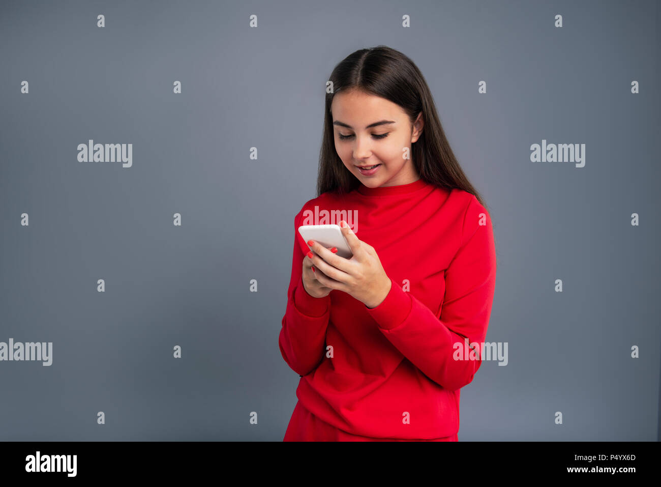 Dark-haired teenage girl texting her friends Stock Photo - Alamy