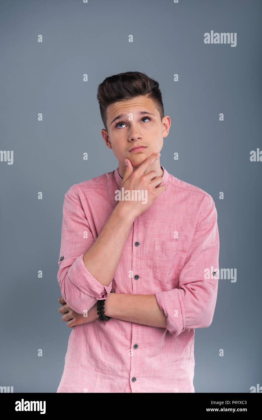 Cute teenage boy thinking about something Stock Photo - Alamy