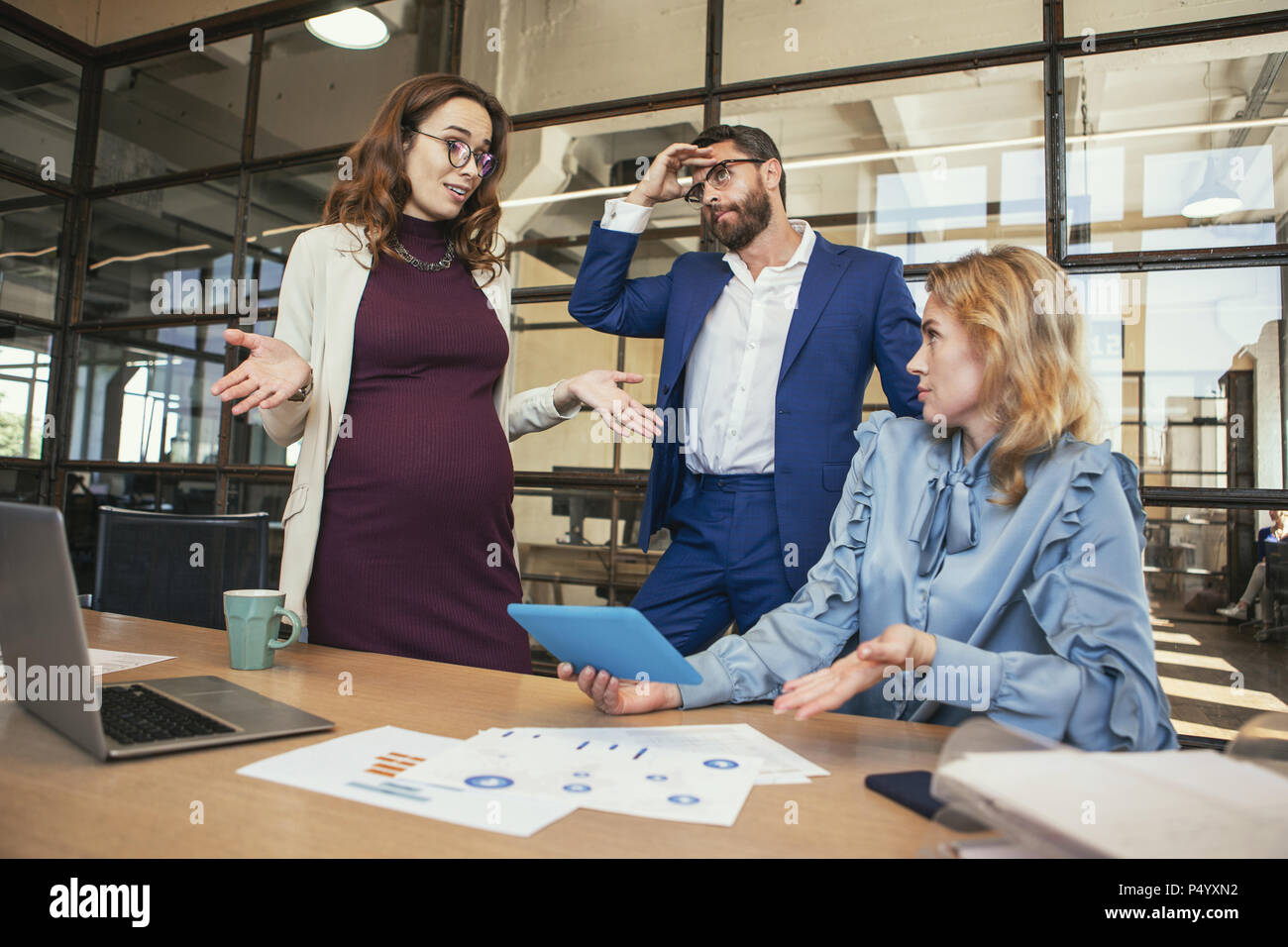 Disturbed three colleagues facing problem Stock Photo - Alamy