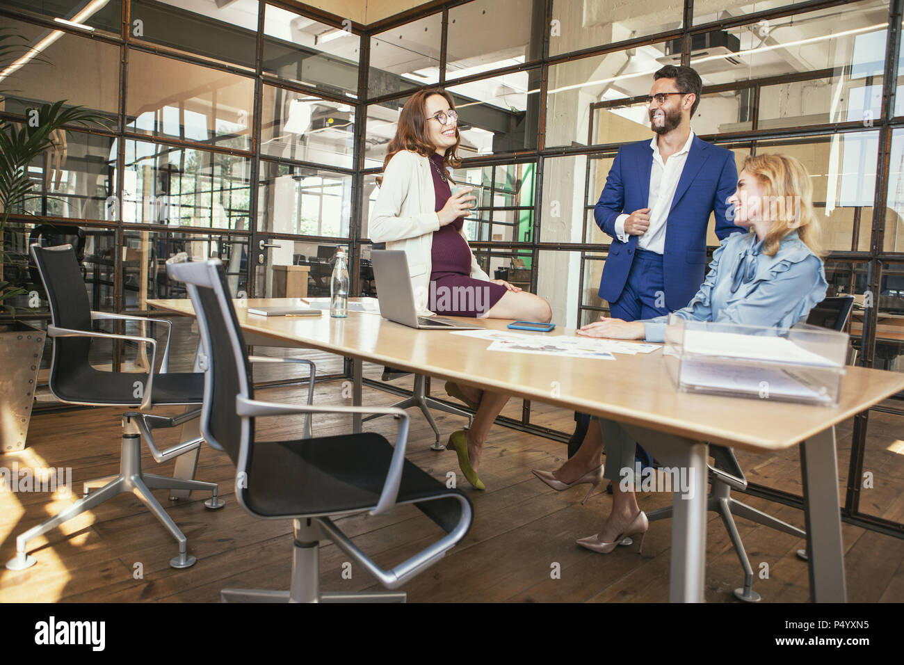 Optimistic three colleagues enjoying work Stock Photo - Alamy