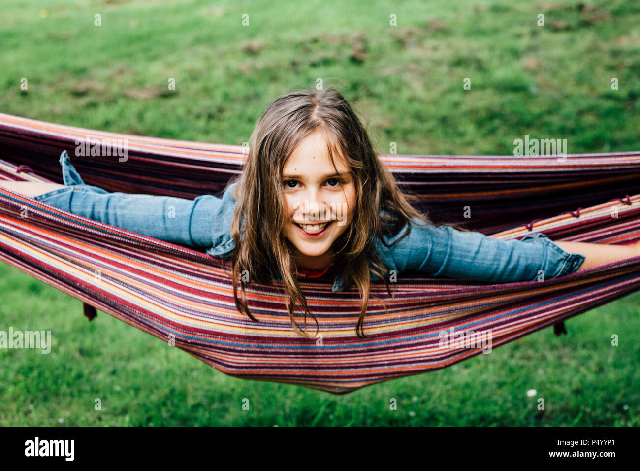 Portrait Smiling Girl Lying Hammock Sticking Out Tongue Hi Res Stock
