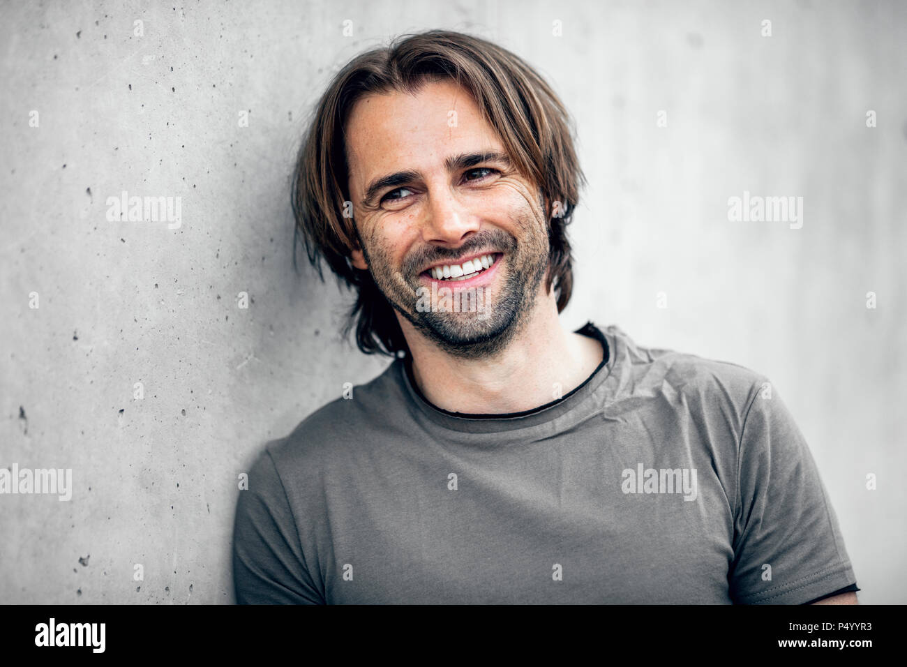 Portrait of smiling athlete at concrete wall Stock Photo - Alamy
