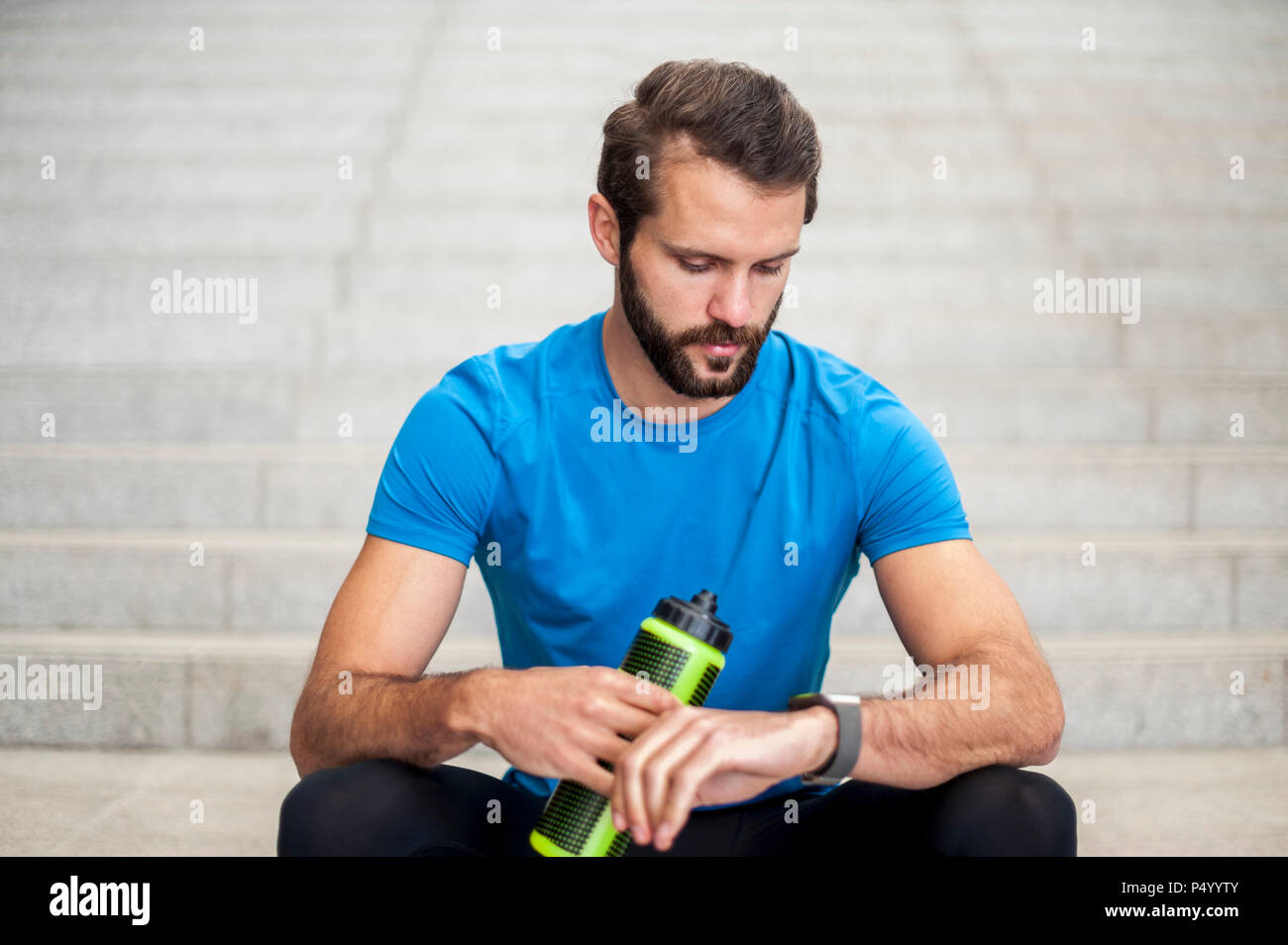 Man sitting on stairs having a break from running Stock Photo - Alamy