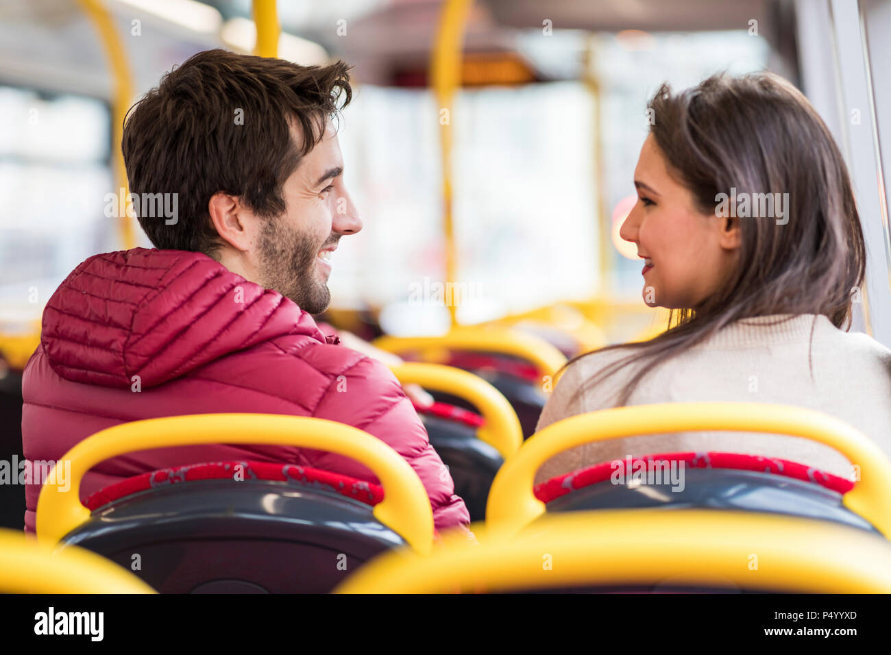 UK, London, happy young couple sitting side by side in bus Stock Photo ...