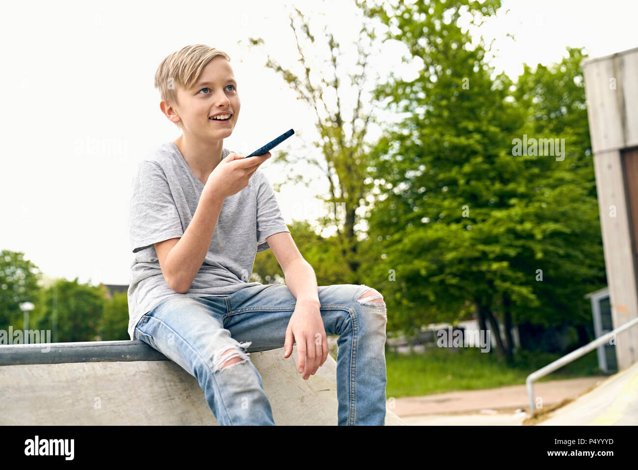 Boy recording voice message on smartphone Stock Photo - Alamy