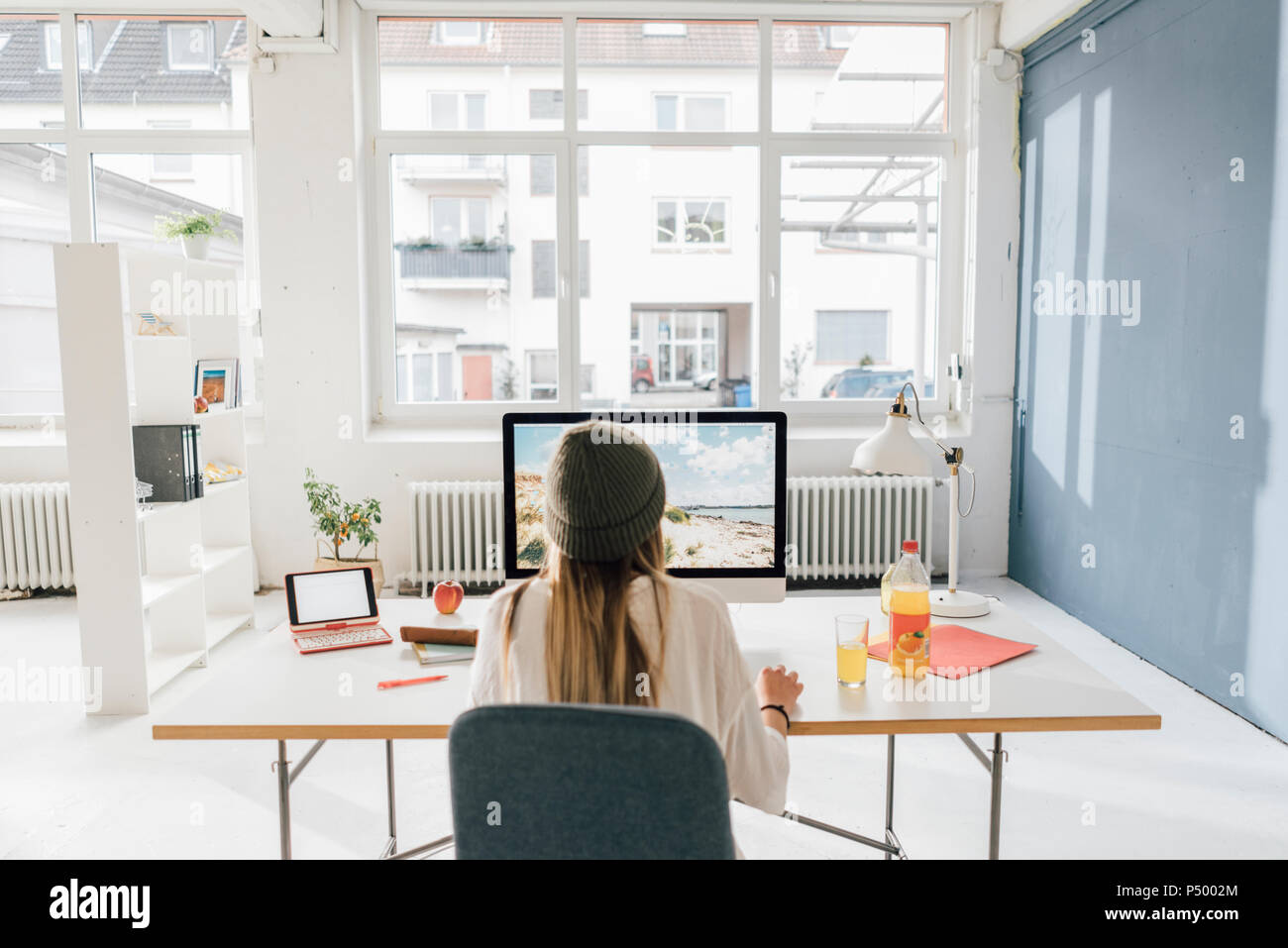 Back view of freelancer working at desk in a loft Stock Photo - Alamy