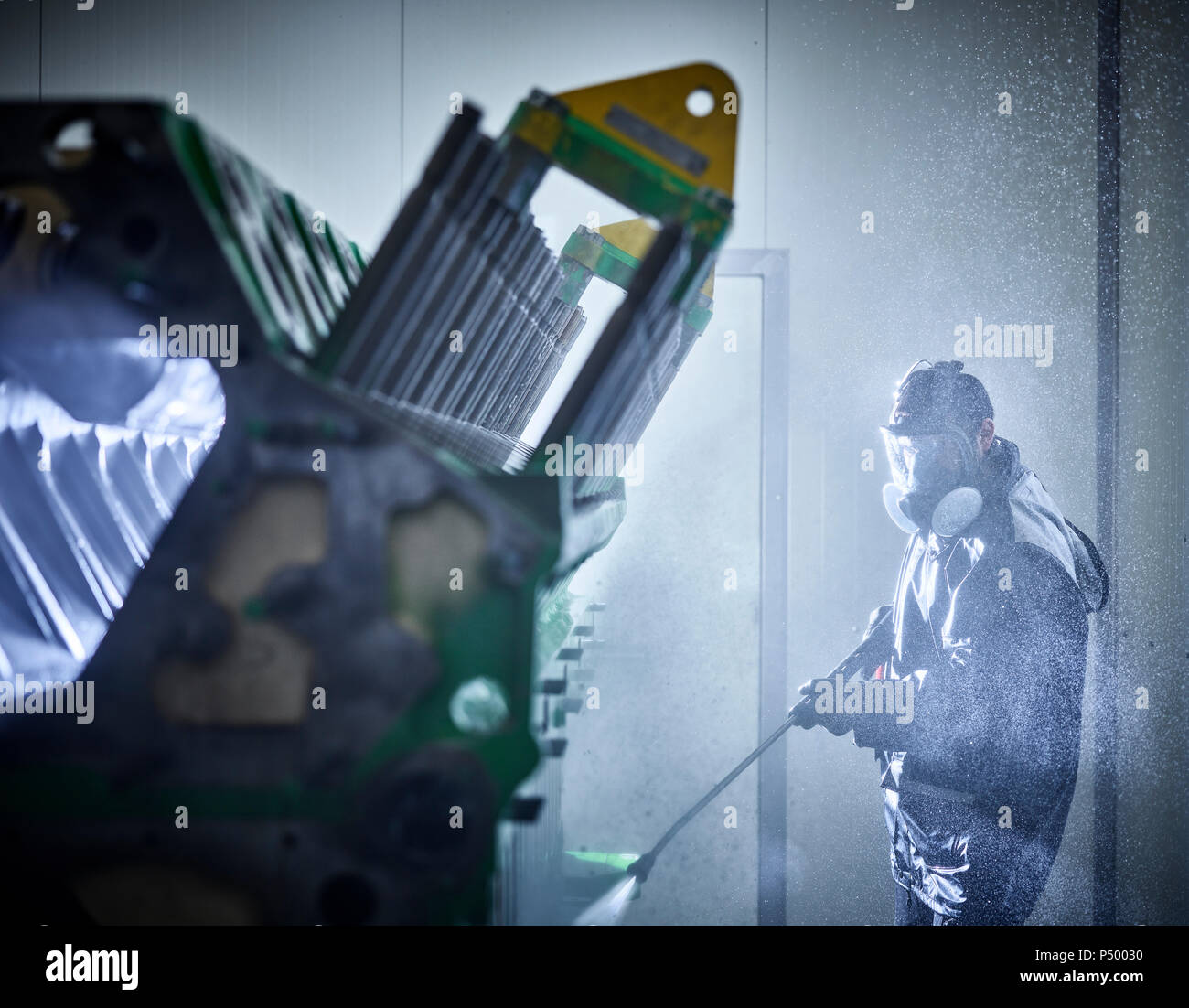 Worker cleaning engine block in washing bay Stock Photo - Alamy