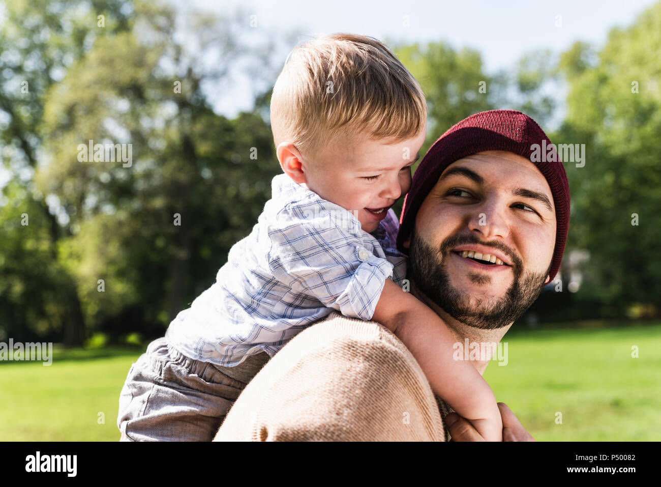 Happy father carrying son on shoulders in a park Stock Photo - Alamy