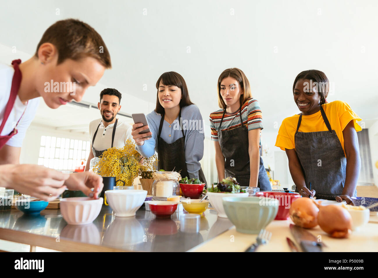 Friends in a cooking workshop watching instructor Stock Photo - Alamy