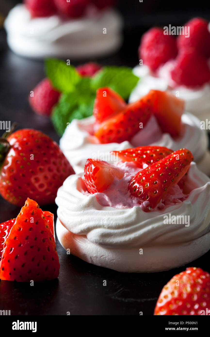 Meringue pastry garnished with whipped cream and strawberries Stock ...