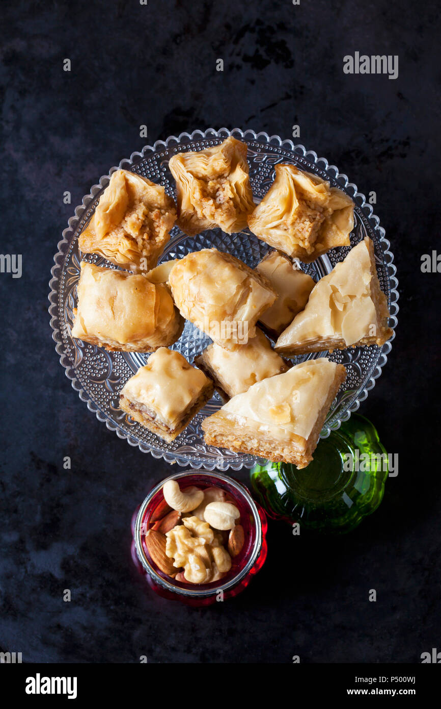 Baklava on cake stand and bowl of nuts on dark ground Stock Photo - Alamy
