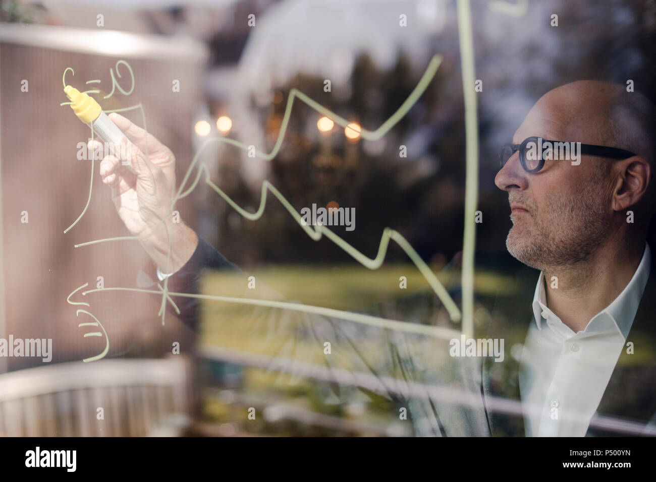 senior businessman brainstorming, drawing formulas on window pane Stock ...