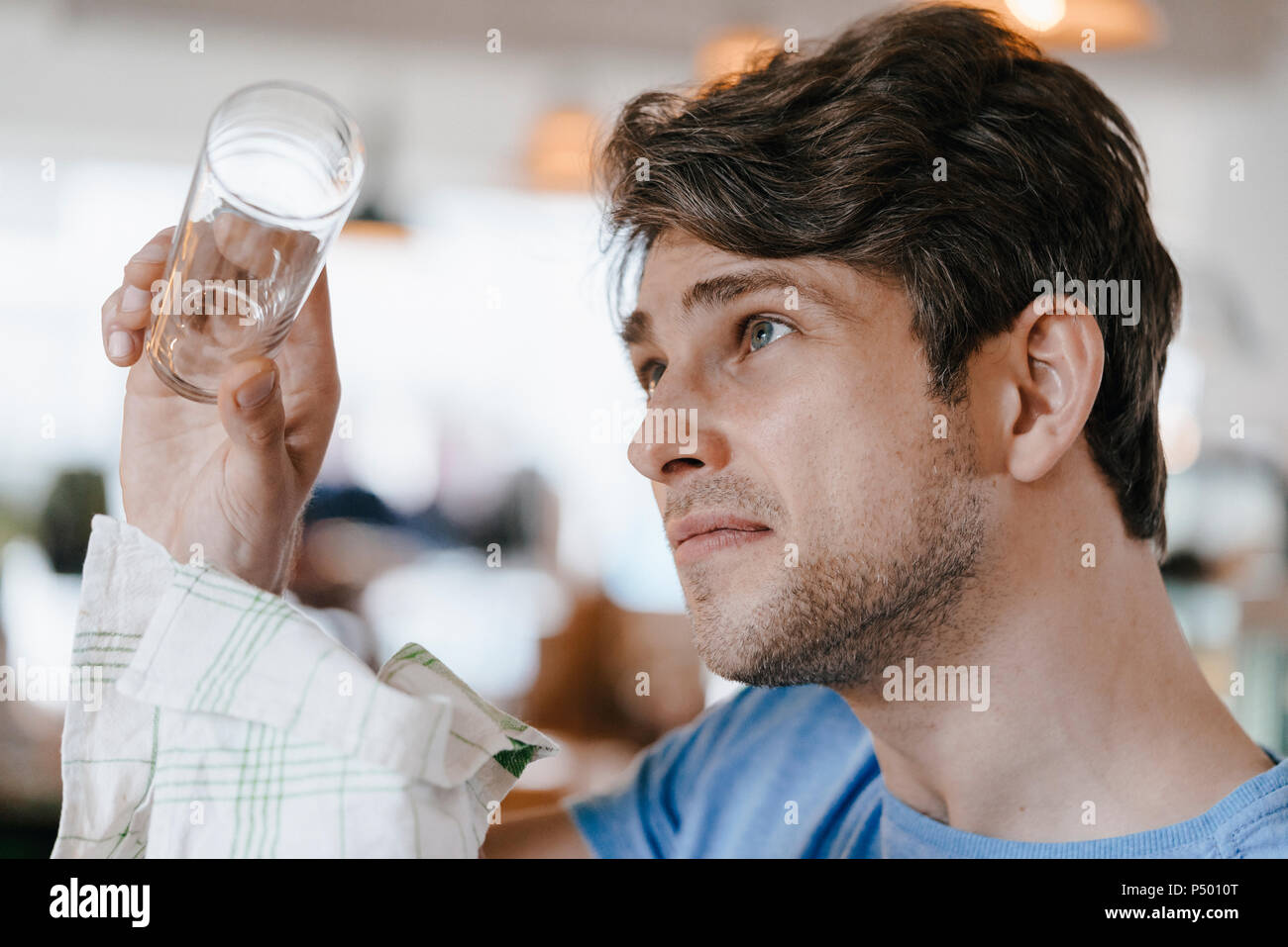 Man in a cafe examining glass Stock Photo - Alamy