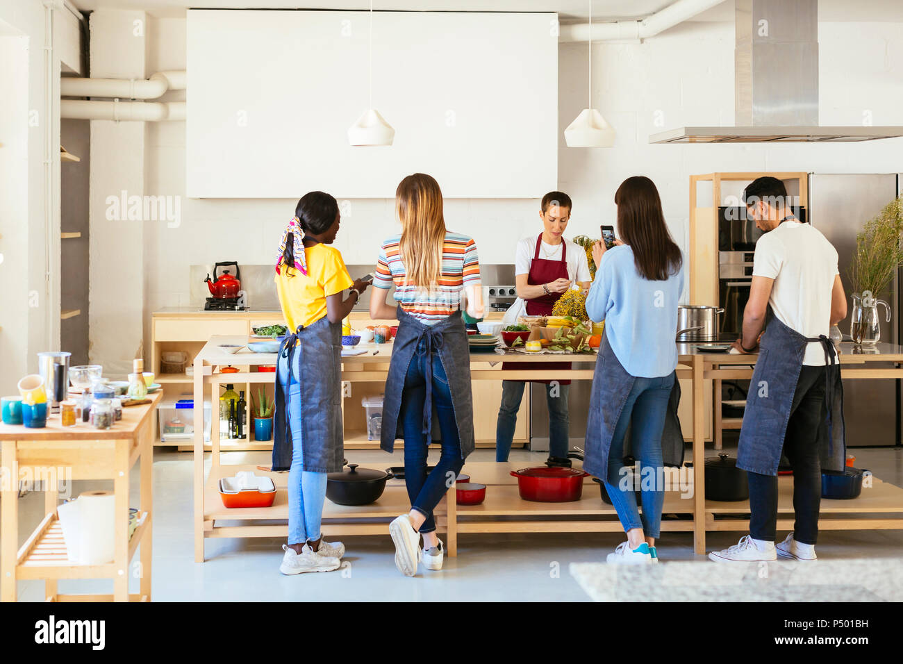Friends and instructor in a cooking workshop preparing food Stock Photo ...
