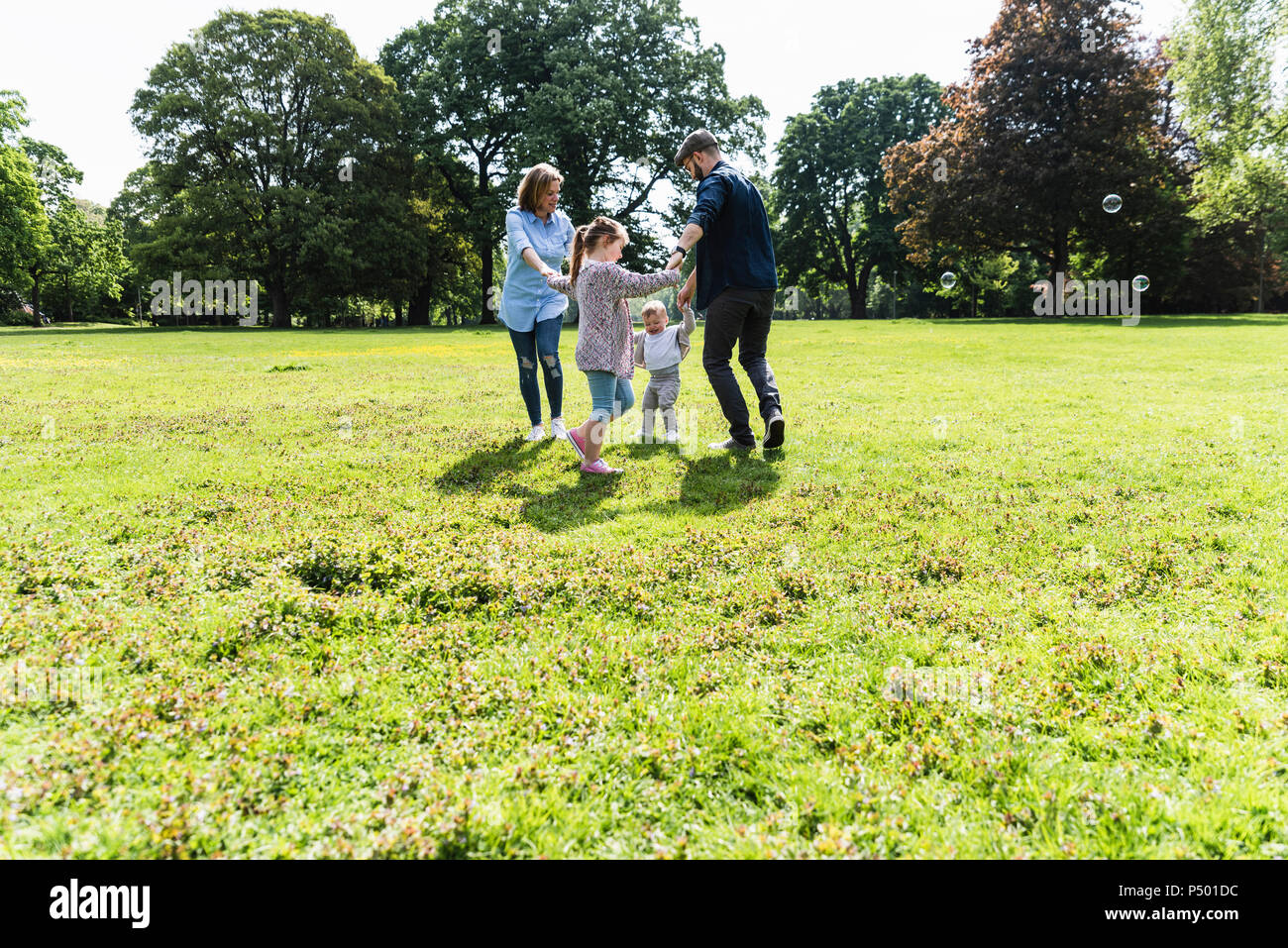 Active happy family in a park Stock Photo - Alamy