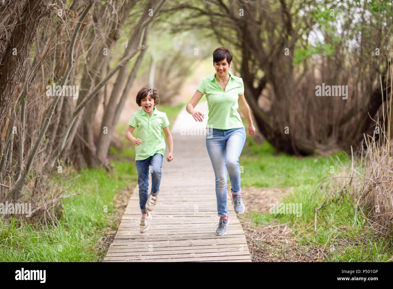 Happy mother and daughter running on boardwalk Stock Photo - Alamy