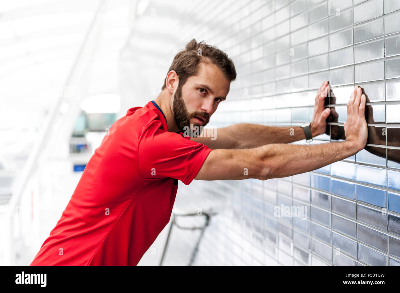 Man stetching at brick wall Stock Photo - Alamy