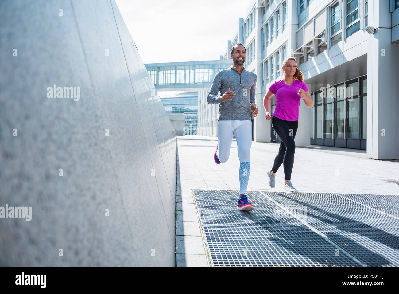 Couple running in the city Stock Photo - Alamy
