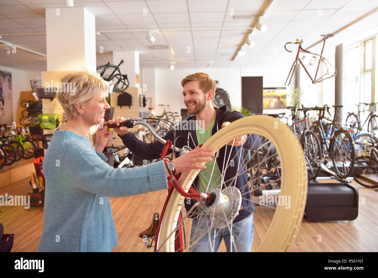 Salesperson helping customer in bicycle shop Stock Photo - Alamy