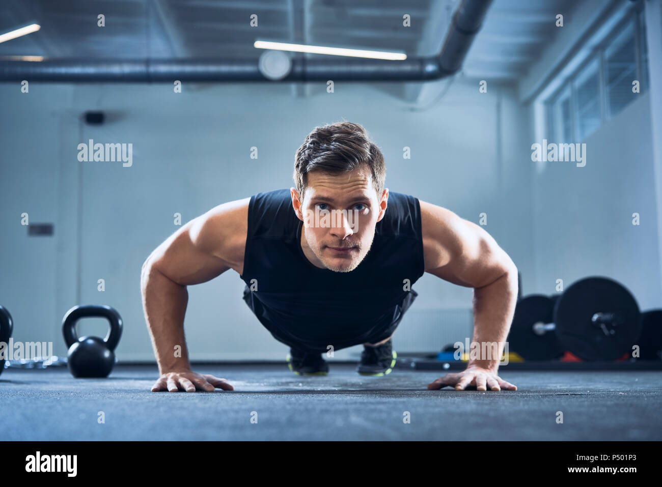 Athletic man doing pushups exercise at gym Stock Photo - Alamy