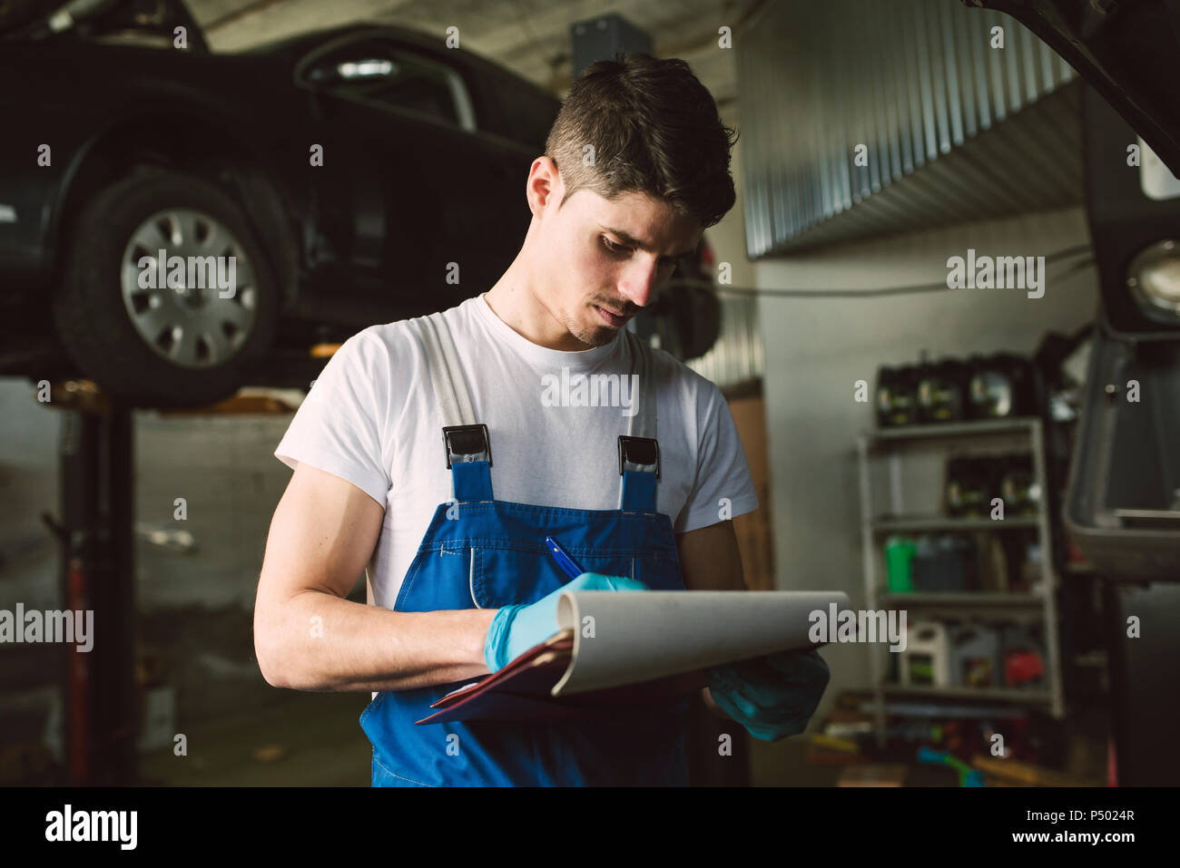 Mechanic with clipboard and checklist in his workshop Stock Photo - Alamy