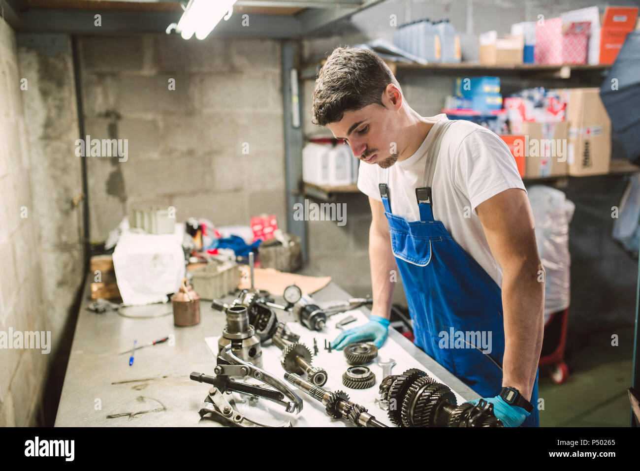 Mechanic overwhelmed by the parts of a car in a workshop Stock Photo ...