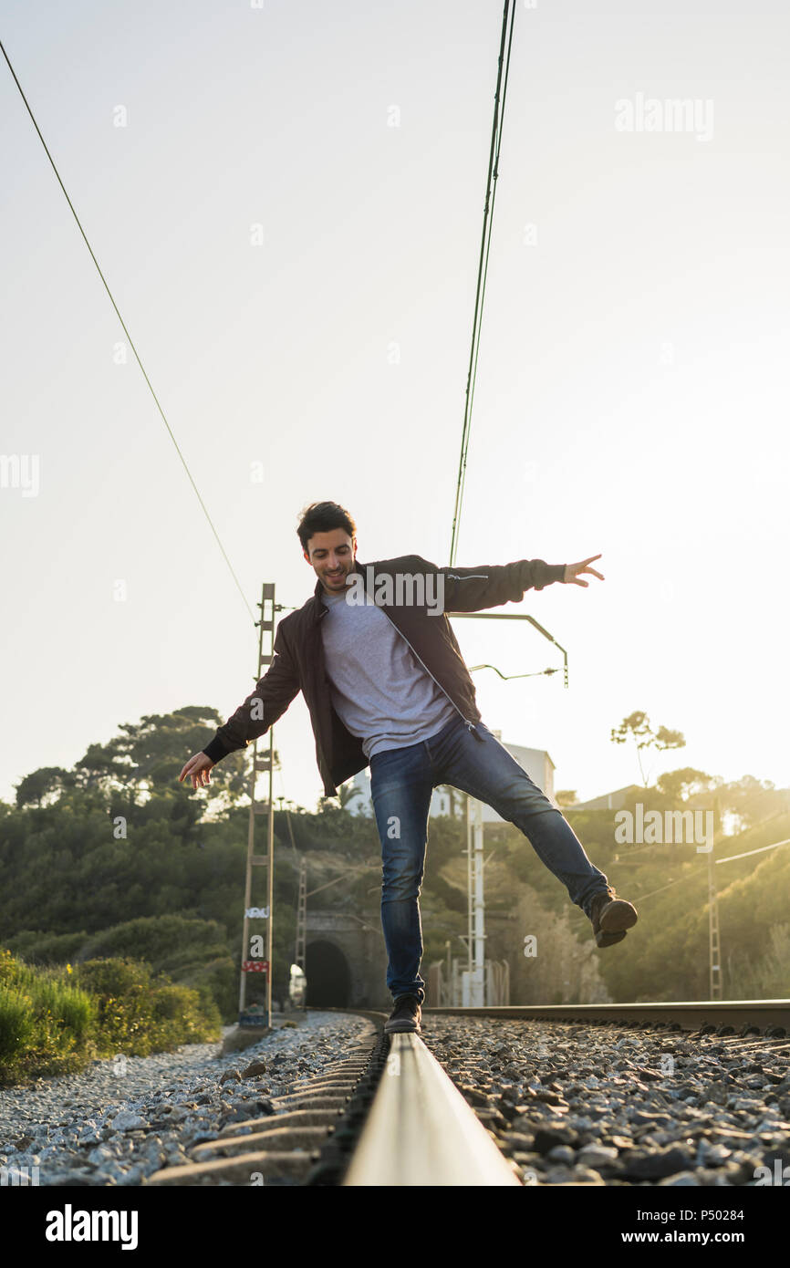 Young man standing on railroad track Stock Photo - Alamy