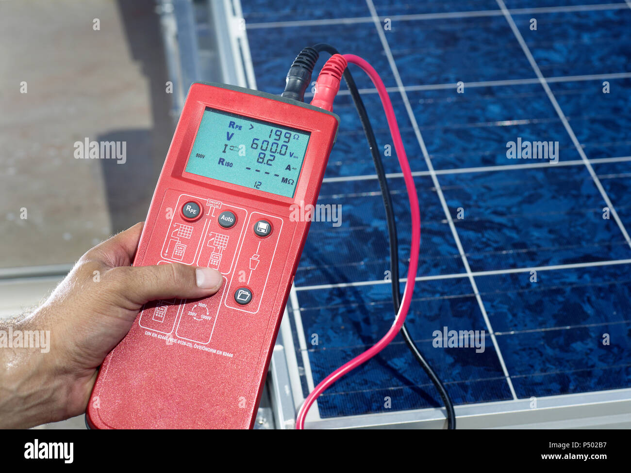 Man's hand holding measuring device in front of solar plant, close-up ...