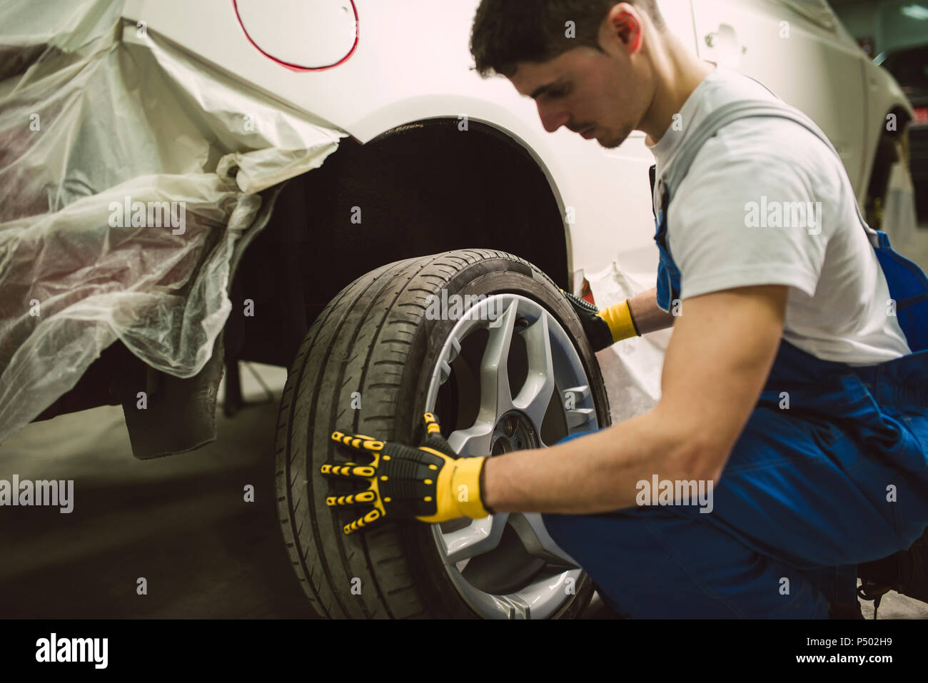 Mechanic changing car tyre in his workshop Stock Photo - Alamy