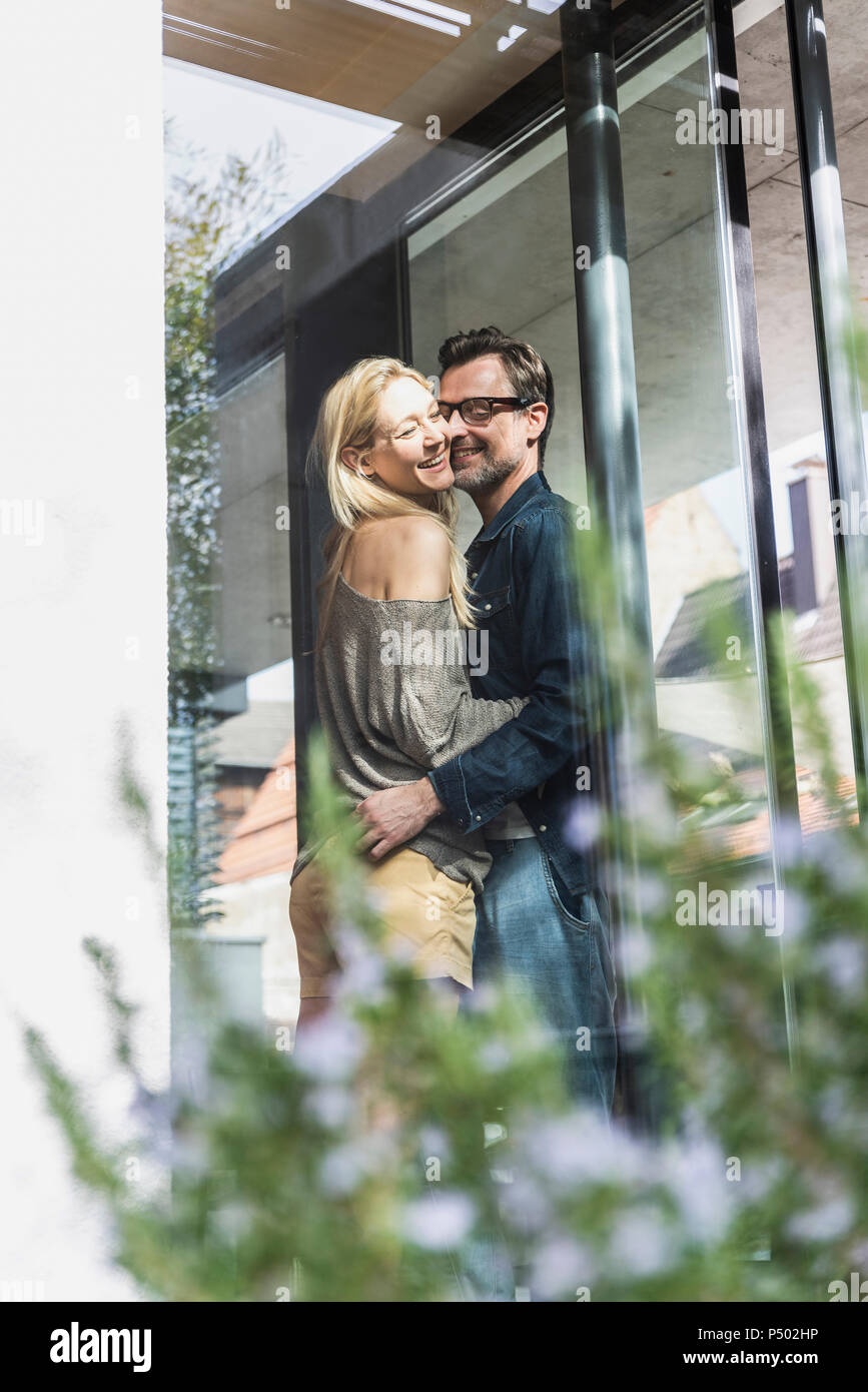 Happy mature couple standing on terrace of their house Stock Photo - Alamy