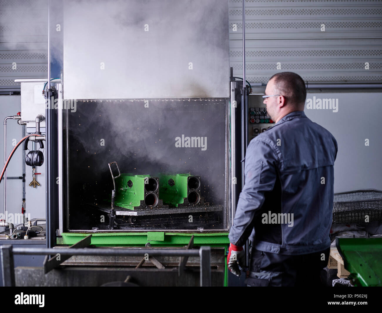 Worker in factory lifting metal plate with crane Stock Photo - Alamy