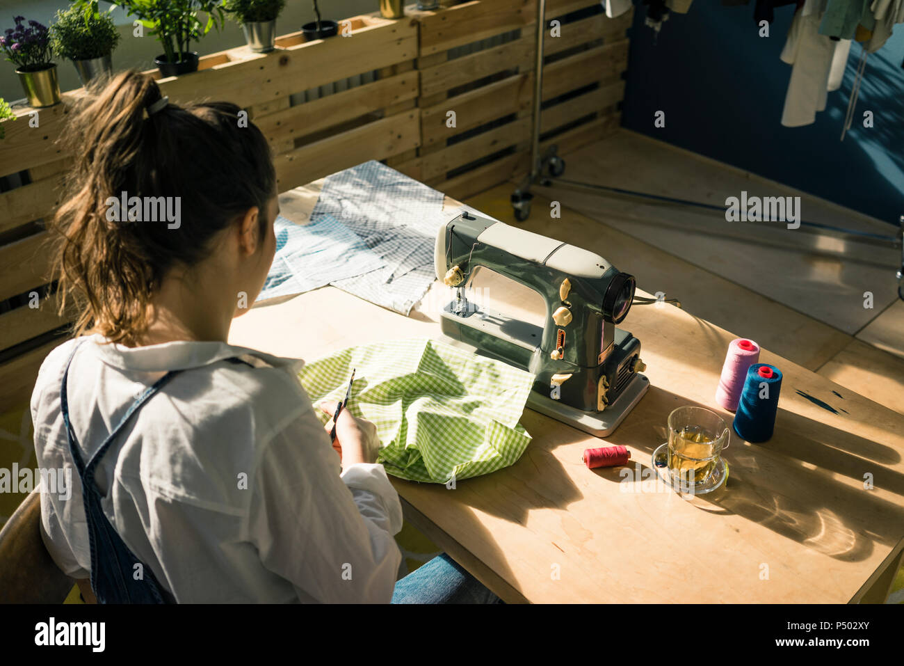 Back view of fashion designer at work in her studio Stock Photo - Alamy