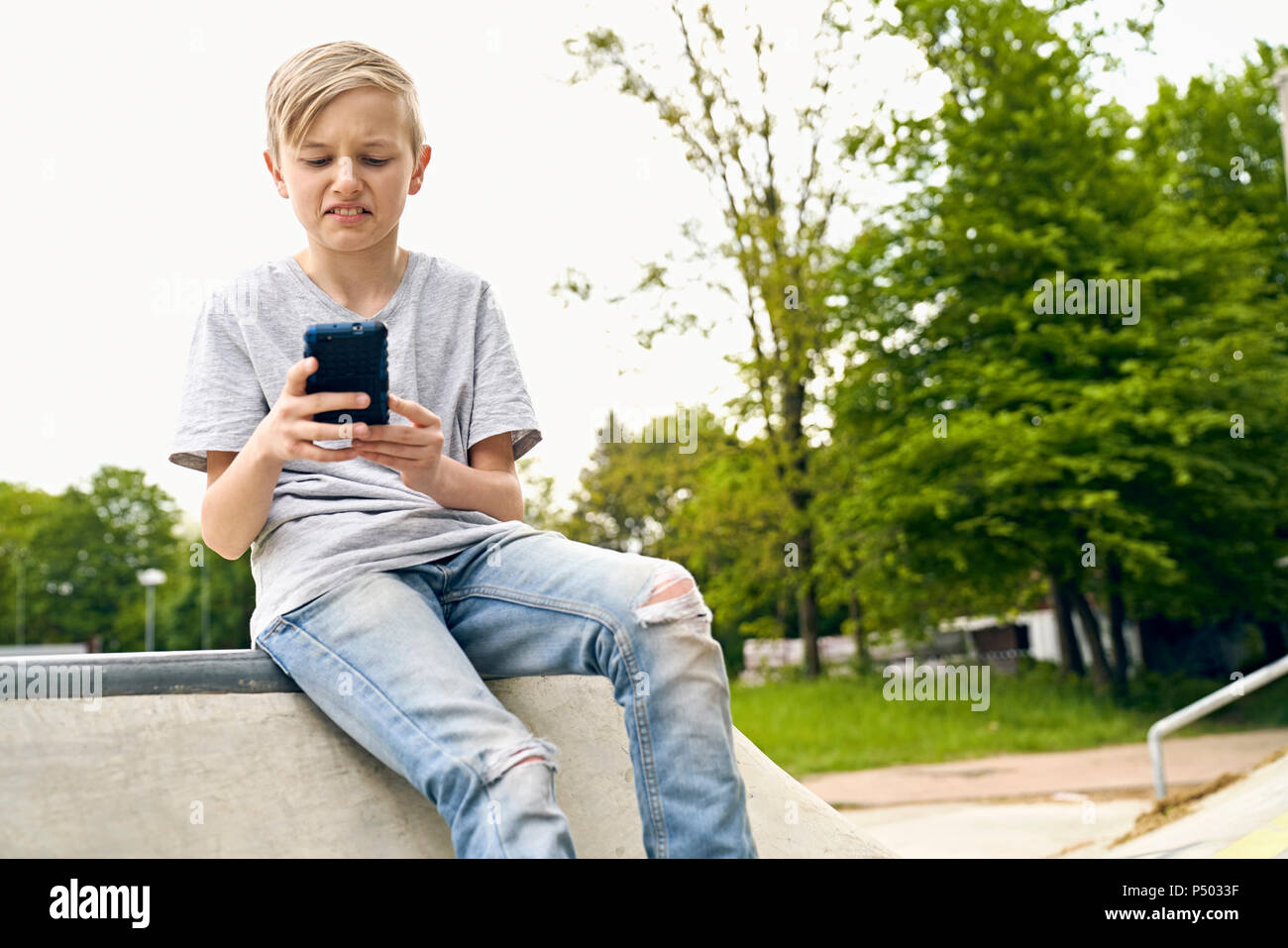 Boy finding something disgusting on smartphone Stock Photo - Alamy