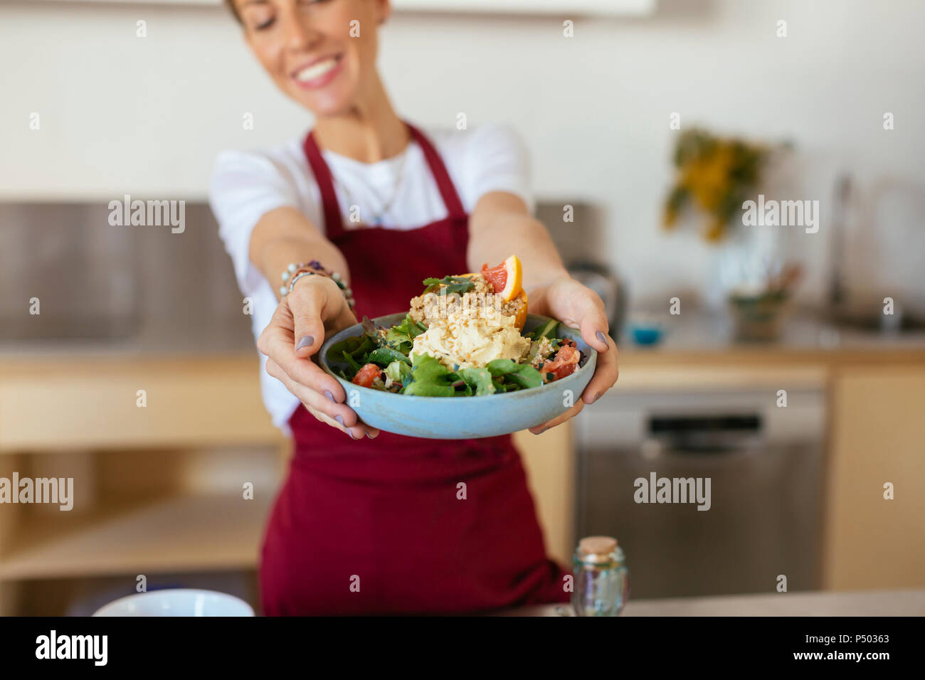 Woman serving meal in kitchen Stock Photo - Alamy