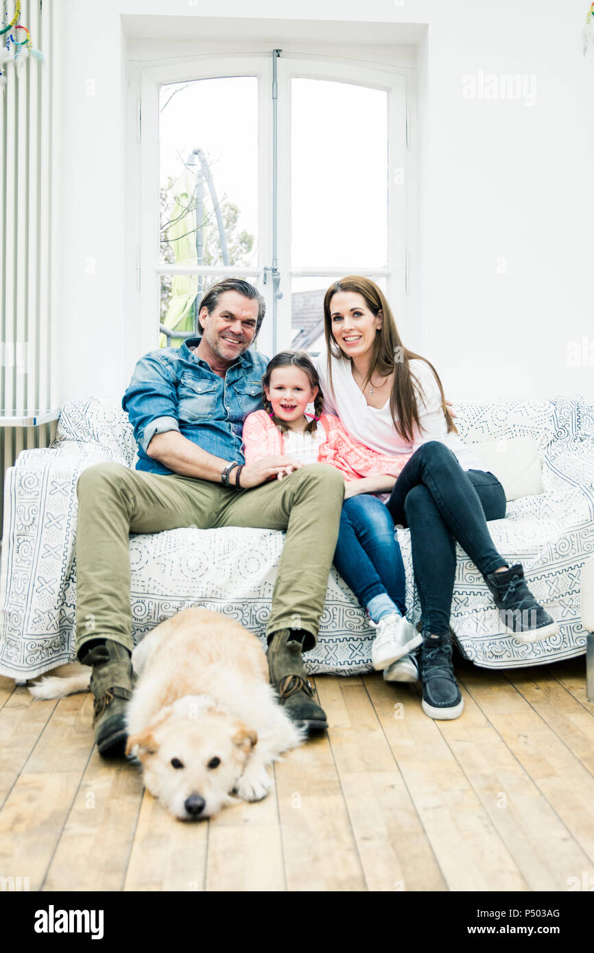 Portrait of happy family with dog in living room Stock Photo - Alamy