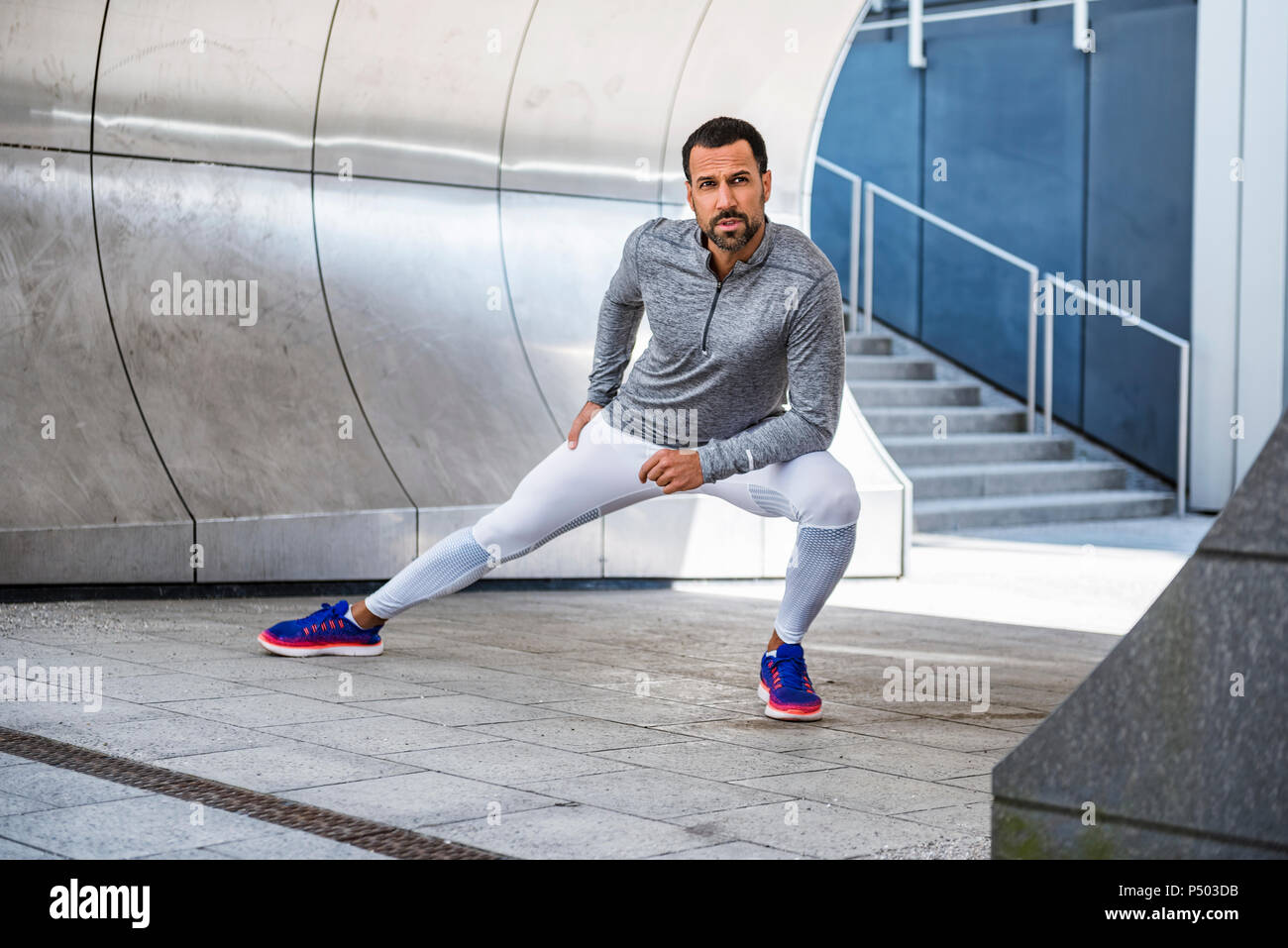 Sportsman doing stretching exercises hi-res stock photography and ...