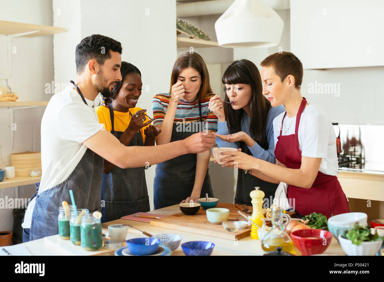 Friends tasting food in a cooking workshop Stock Photo - Alamy