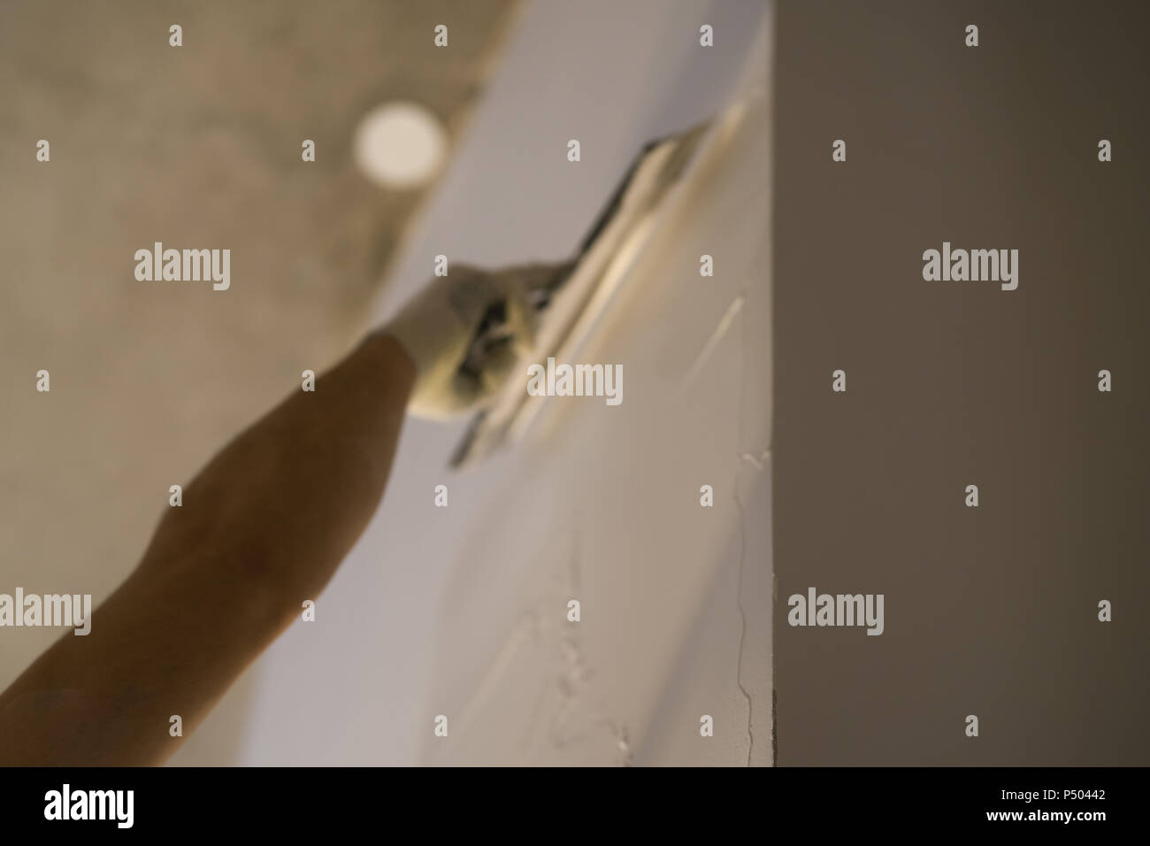 worker applying putty on the wall with putty knife, shallow focus Stock ...