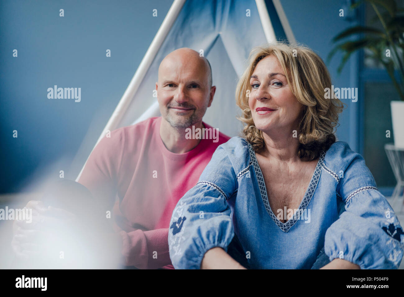 Portrait of smiling couple at teepee indoors Stock Photo - Alamy