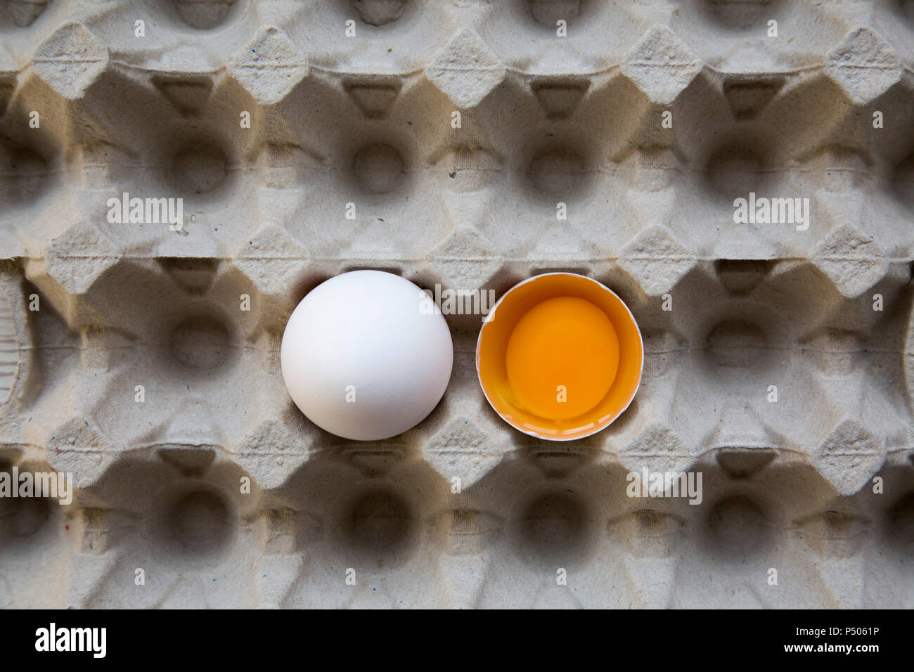 Whole and broken egg on tray, top view. From above. Closeup Stock Photo ...