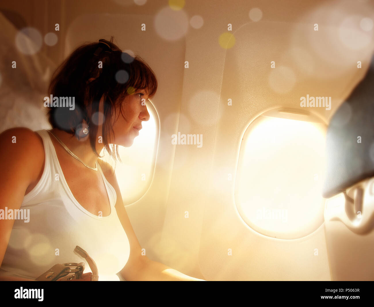 an image of a woman looking from airplane window Stock Photo - Alamy