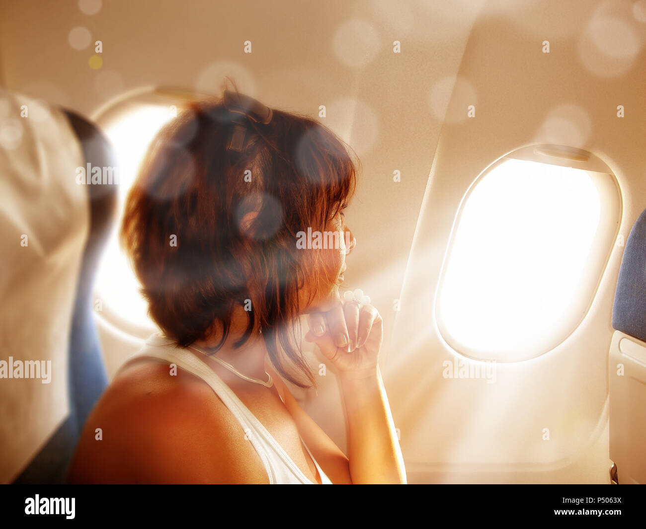 an image of a woman looking from airplane window Stock Photo - Alamy
