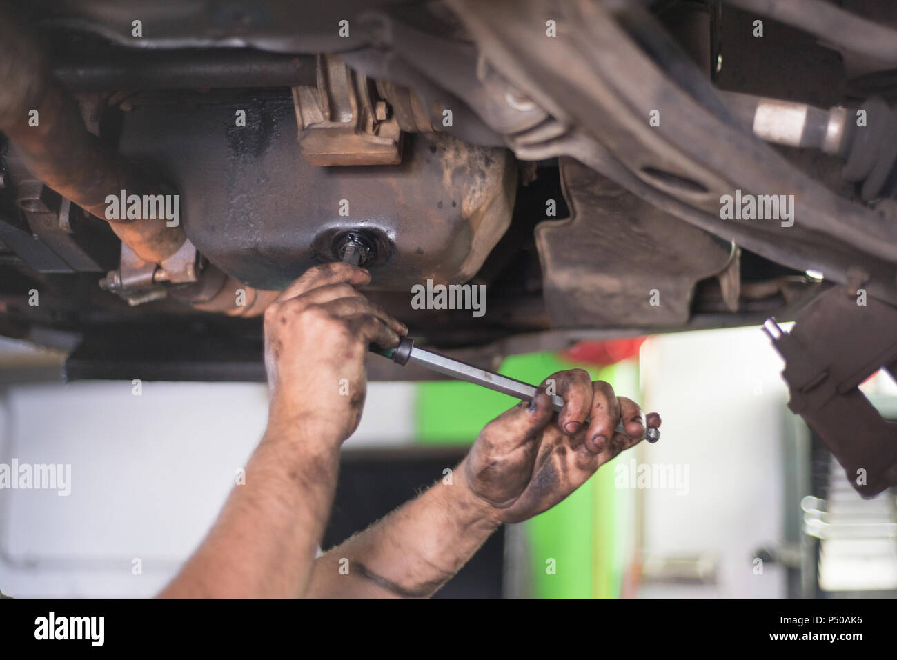 Car mechanic removing used engine oil Stock Photo - Alamy