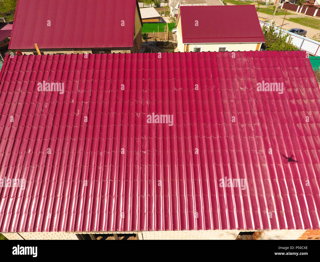 A house with a red roof made of corrugated metal sheets. Roof from ...