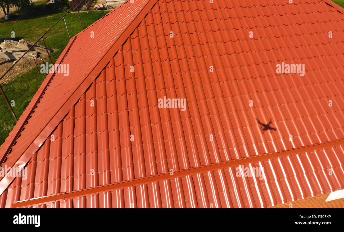 House with an orange roof made of metal, top view. Metallic profile ...