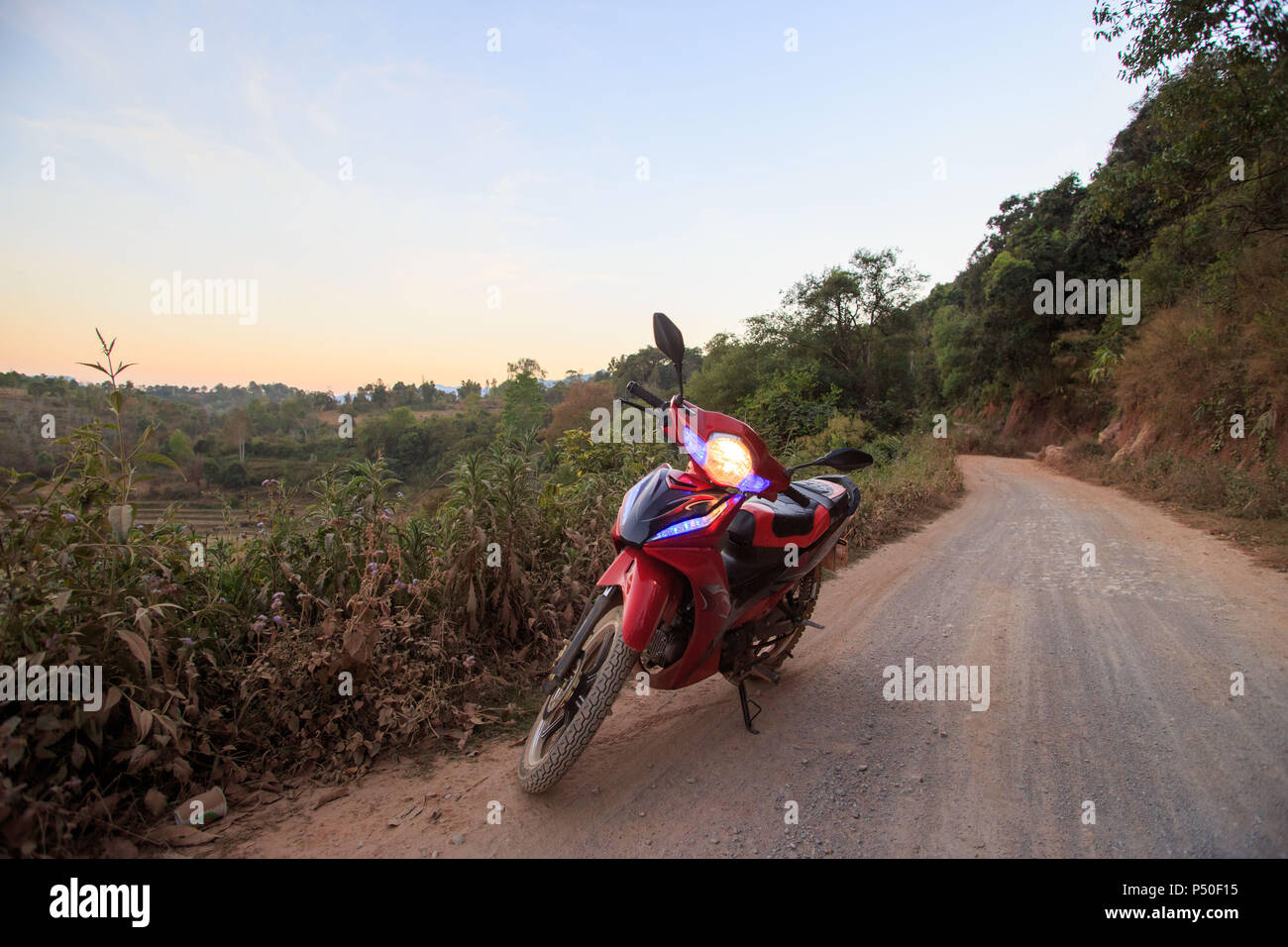 Red motorcycle on dusty dirt road at sunset near Kalaw, Myanmar Stock ...