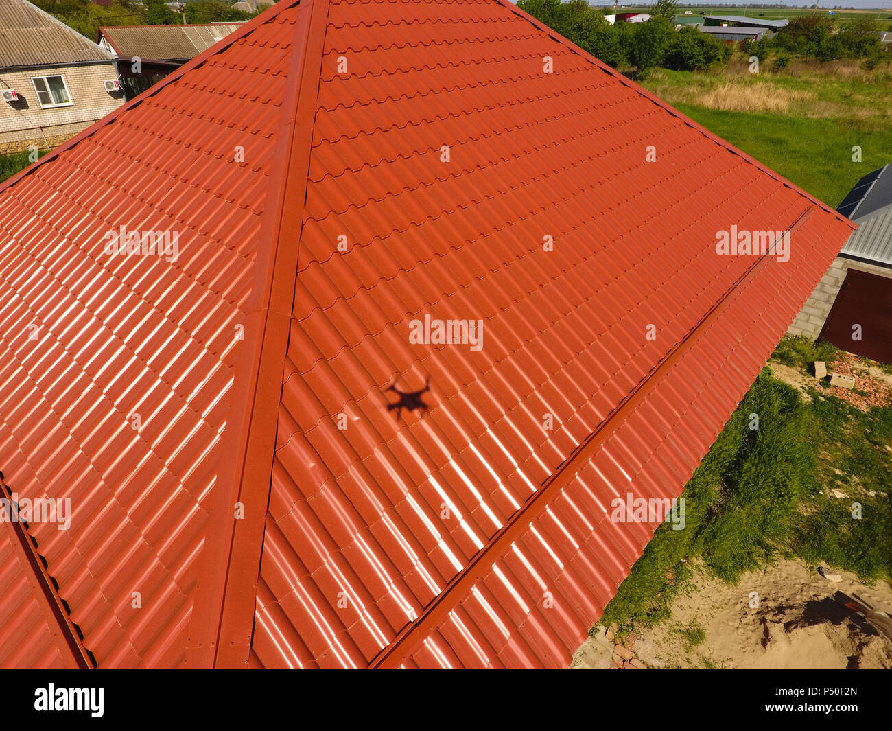 House with an orange roof made of metal, top view. Metallic profile ...